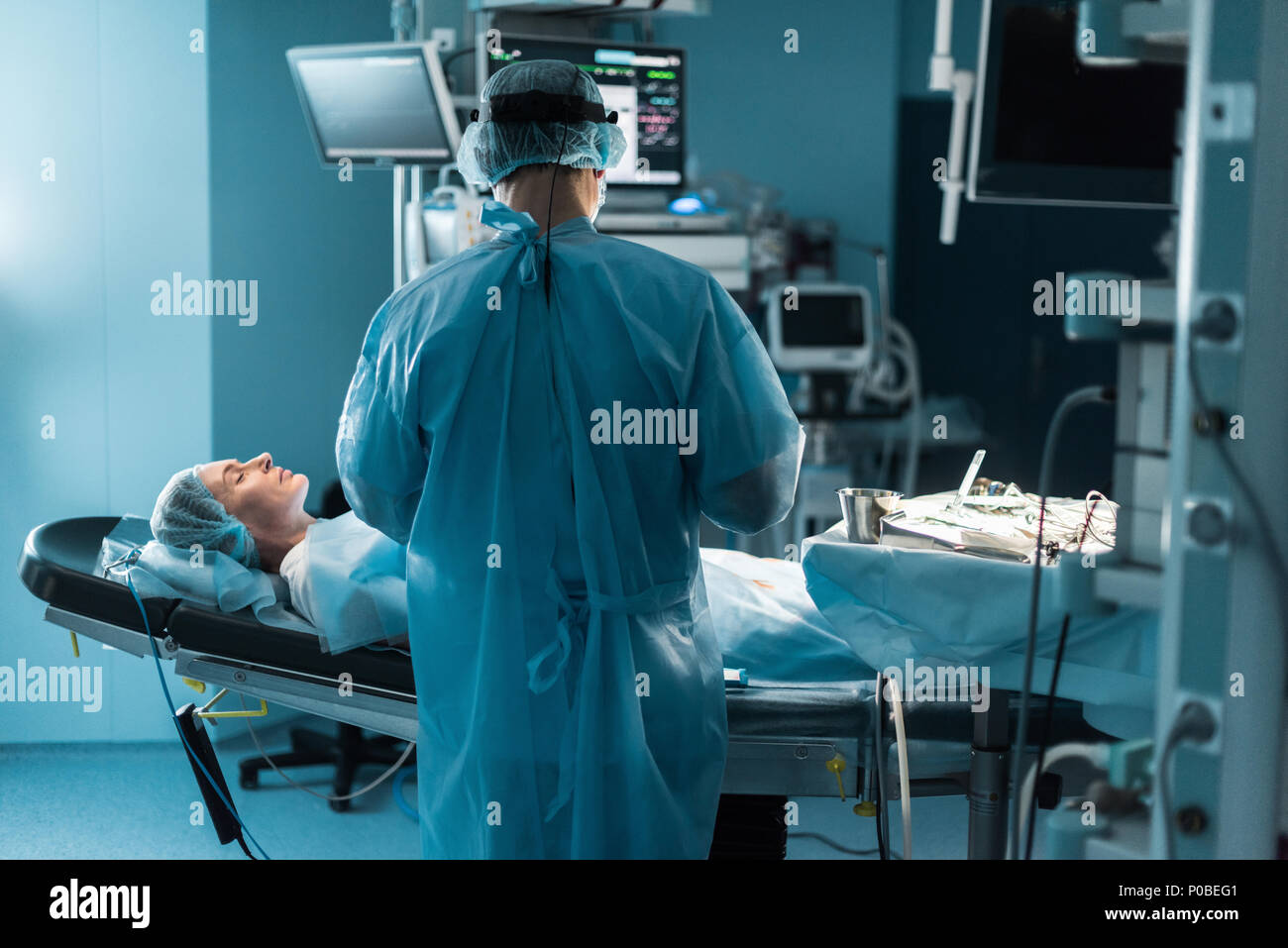back view of surgeon operating patient in operating room Stock Photo ...