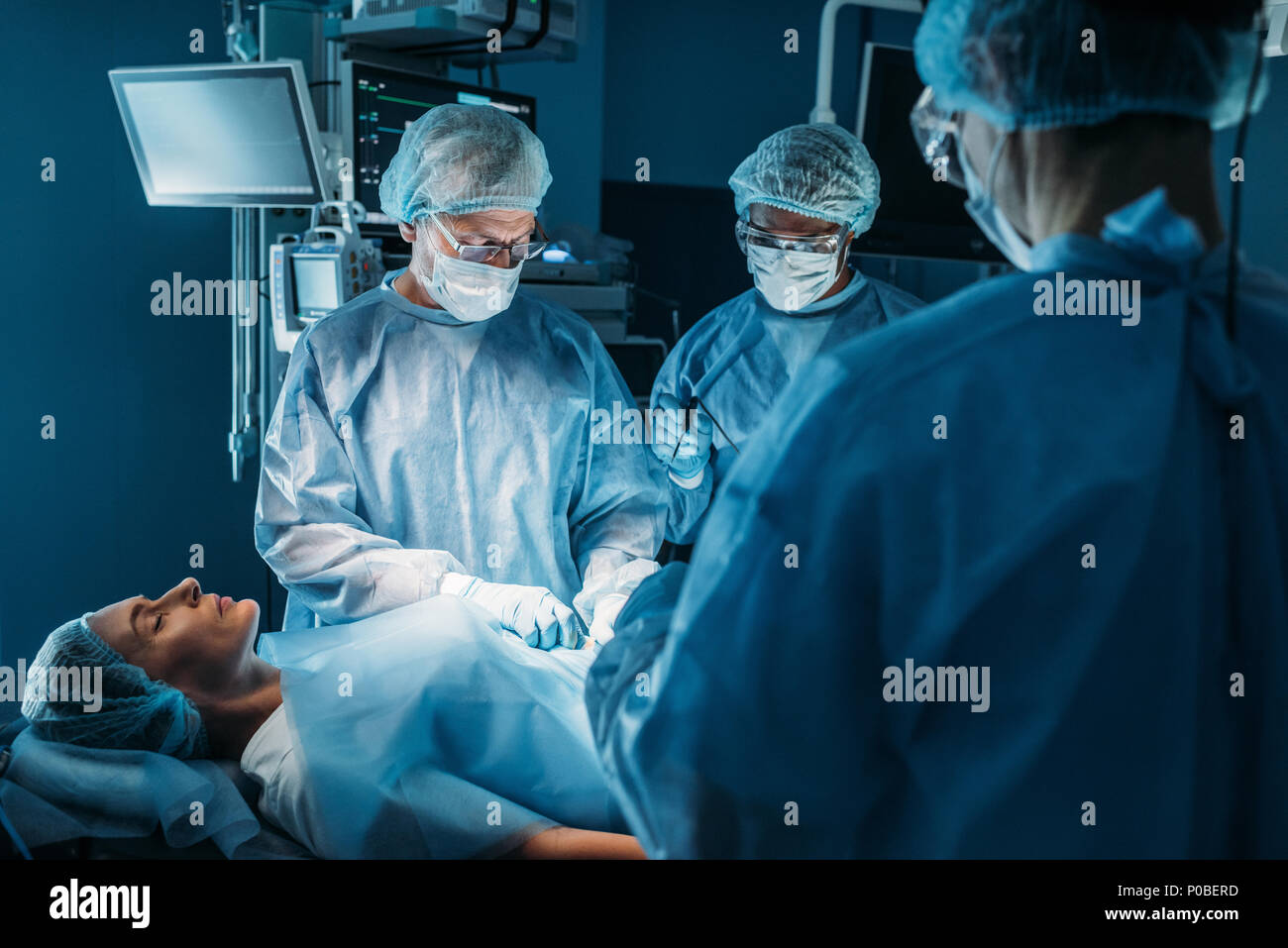 multicultural surgeons operating female patient Stock Photo - Alamy