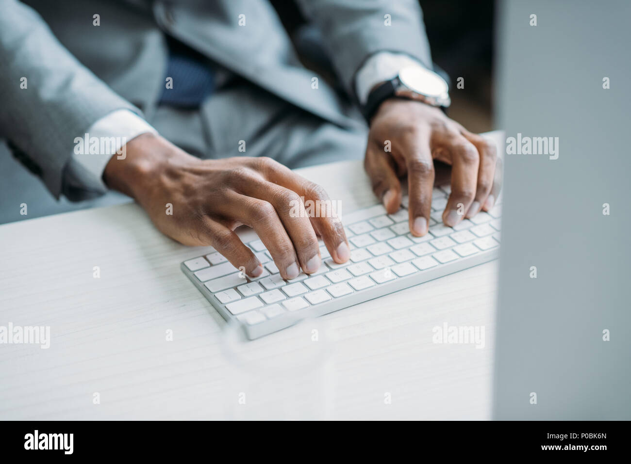 partial view of african american businessman typing on keyboard at ...