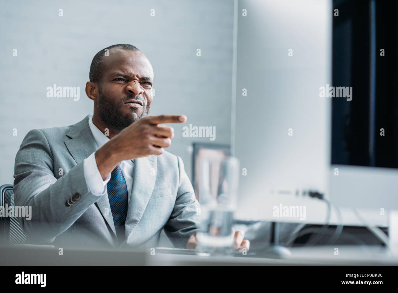 portrait of african american businessman pointing at computer screen at ...