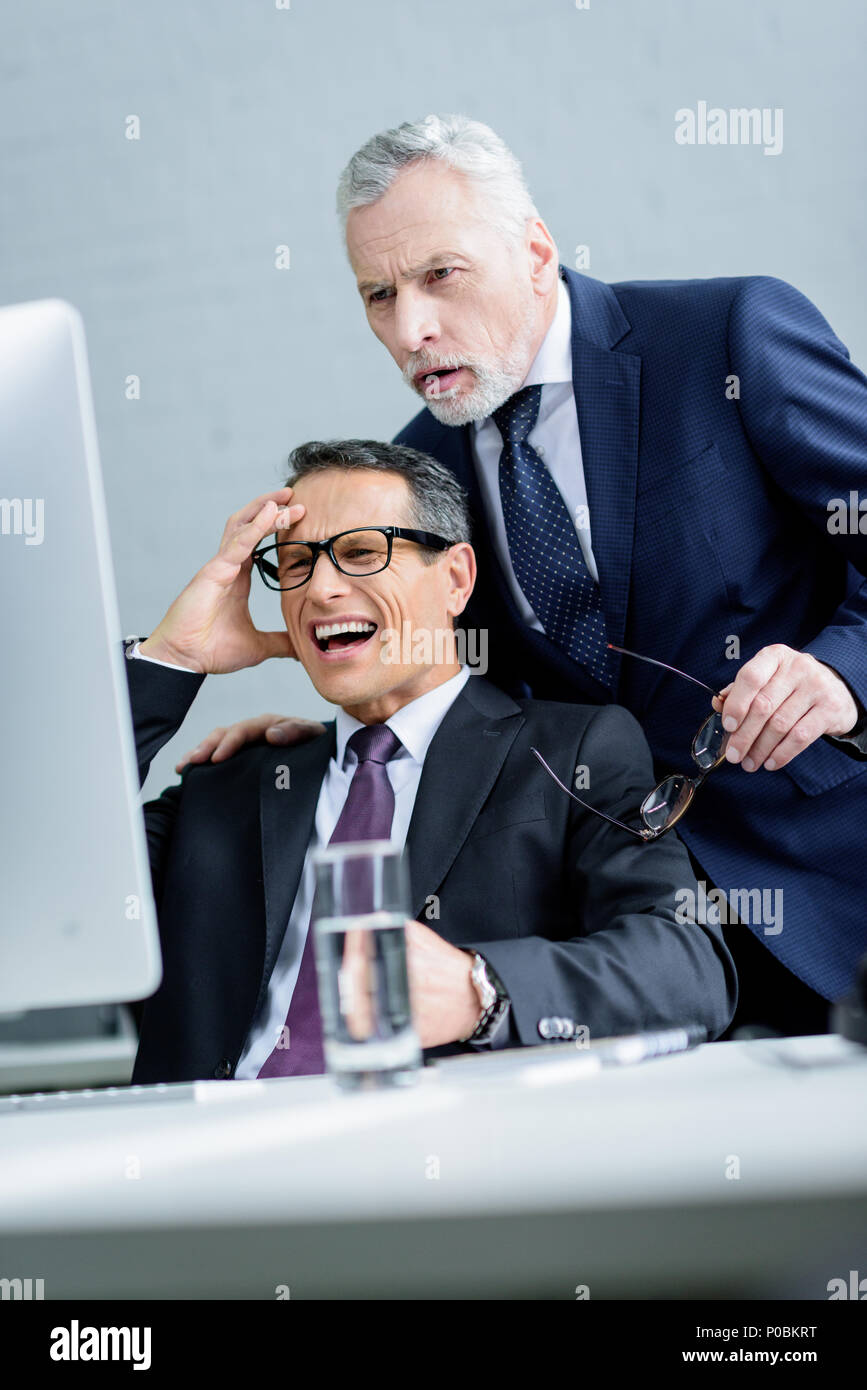 Colleagues looking computer screen in hi-res stock photography and ...