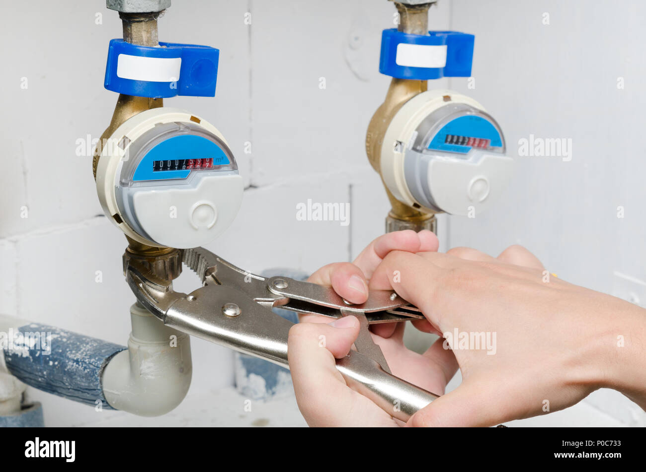 Technician installs a new water meter. Blue modern radio water counter ...