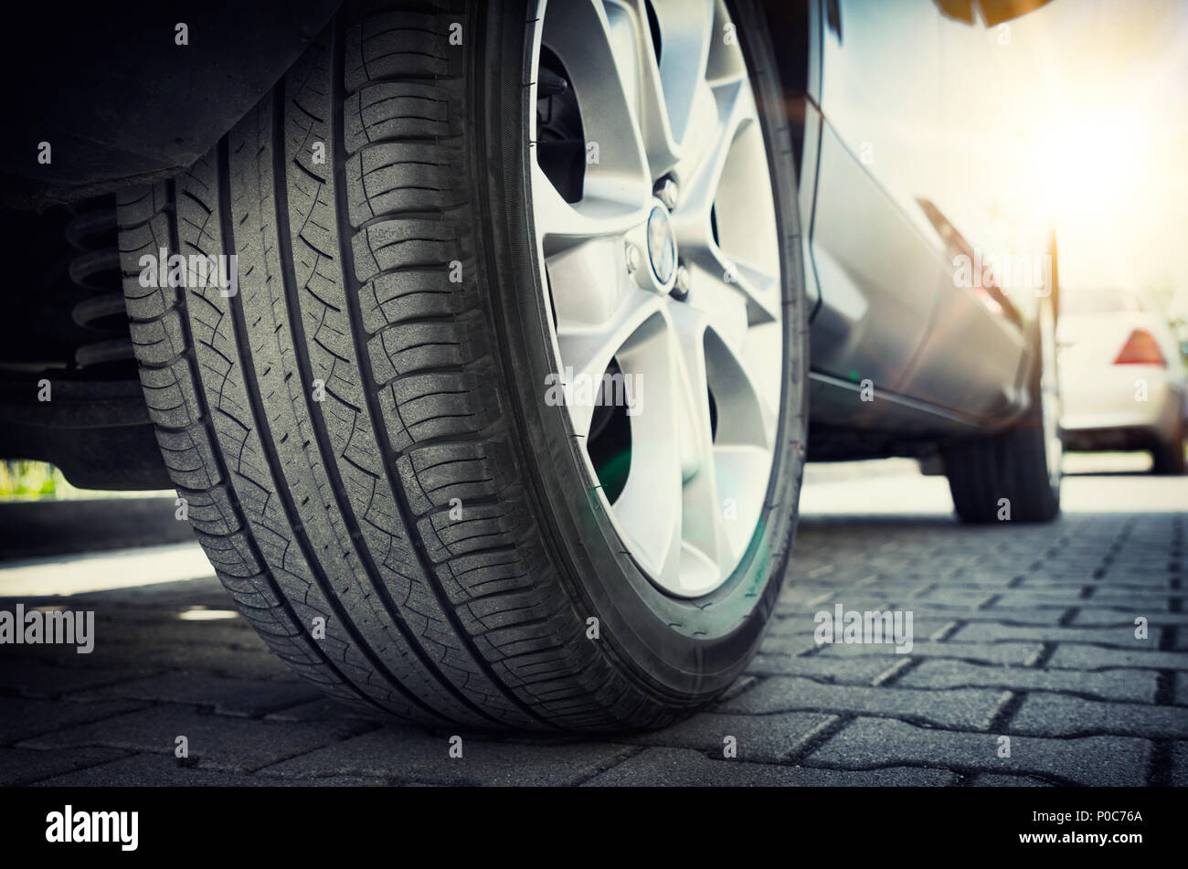 Car all-season tire close up, parked car. Low angle shot, wheel auto ...
