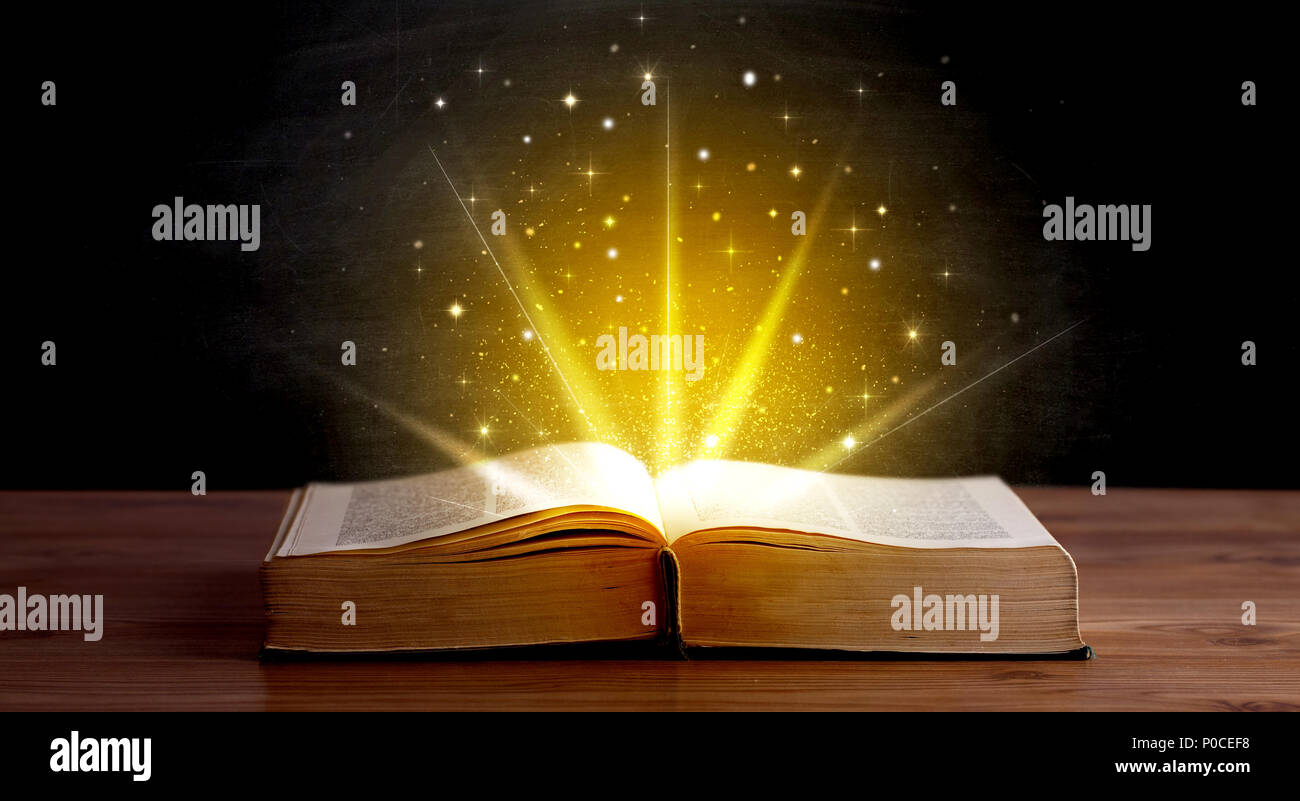 Yellow lights and sparkles coming from an open book Stock Photo - Alamy