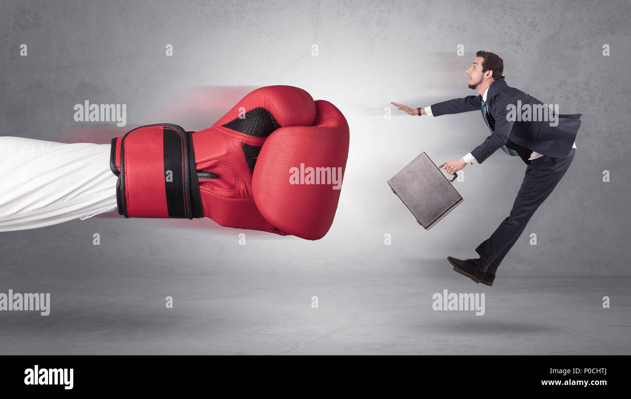 Businessman gets a hit from a giant hand with boxing gloves Stock Photo ...
