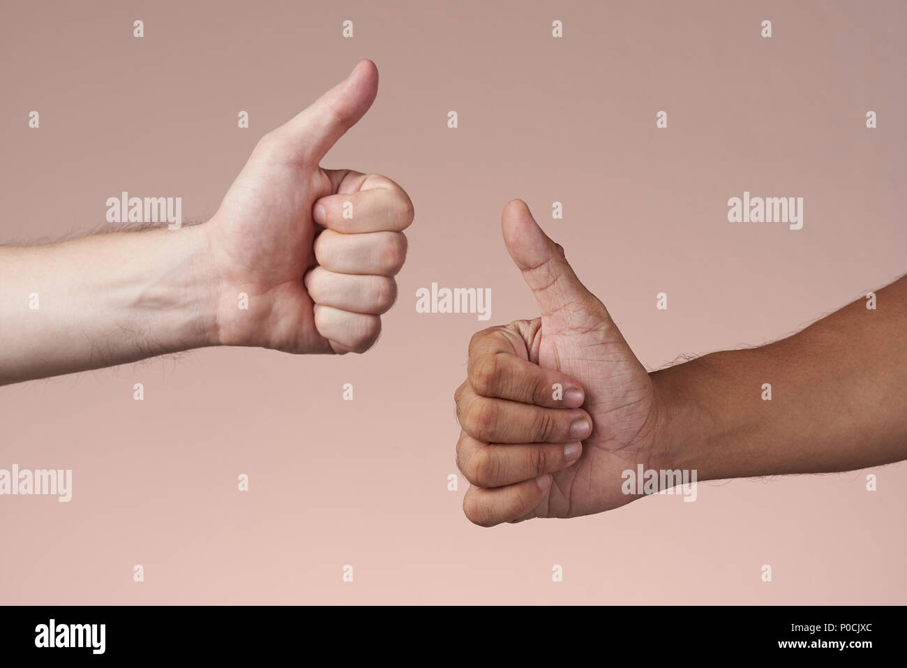 Two hands show thumb up isolated on brown background Stock Photo - Alamy