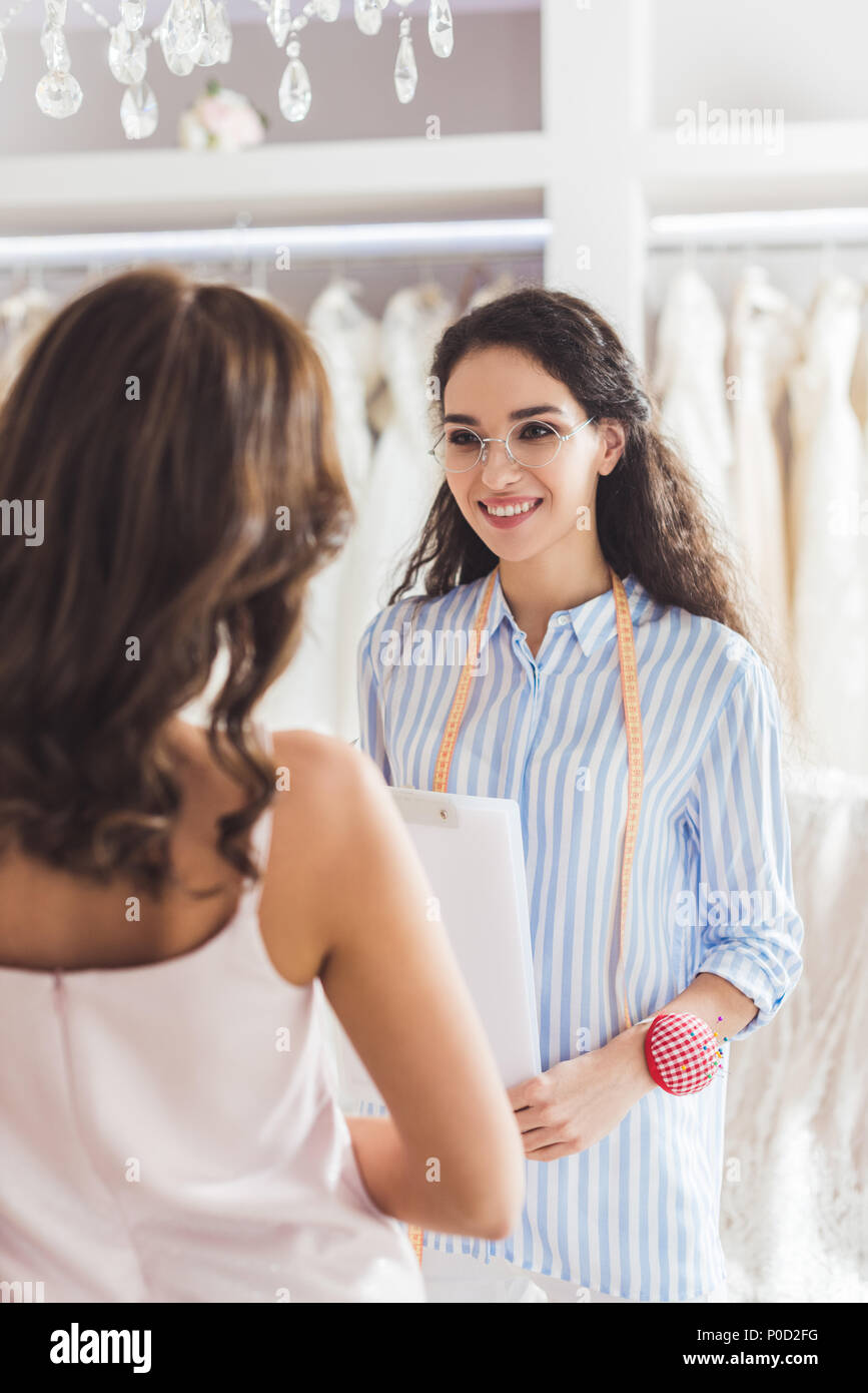 Bride in lace dress and tailor in wedding salon Stock Photo - Alamy