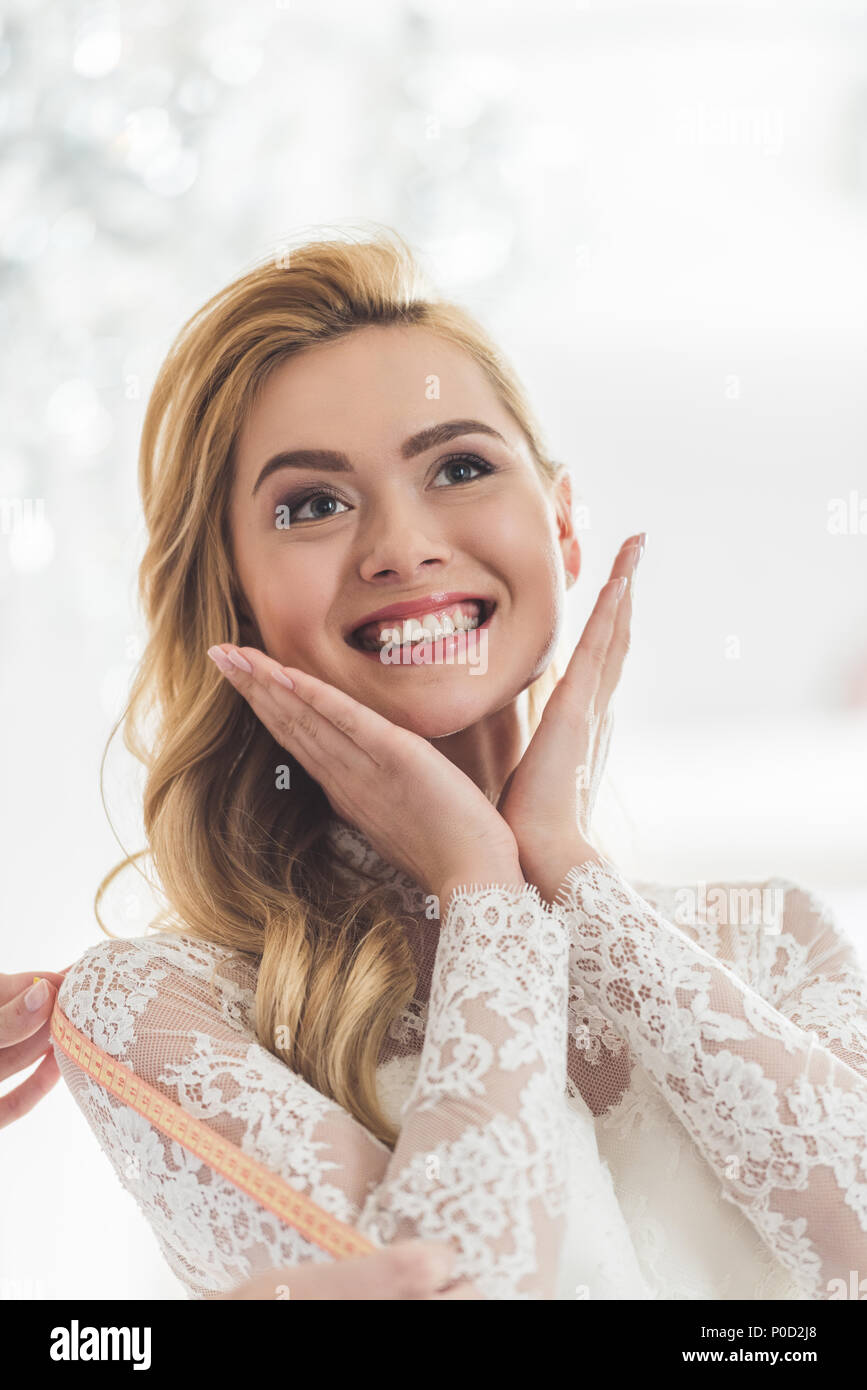 Excited young bride trying on dress in wedding salon Stock Photo - Alamy