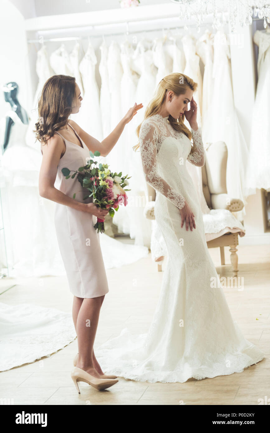 Upset bride with friend holding flowers in wedding salon Stock Photo ...