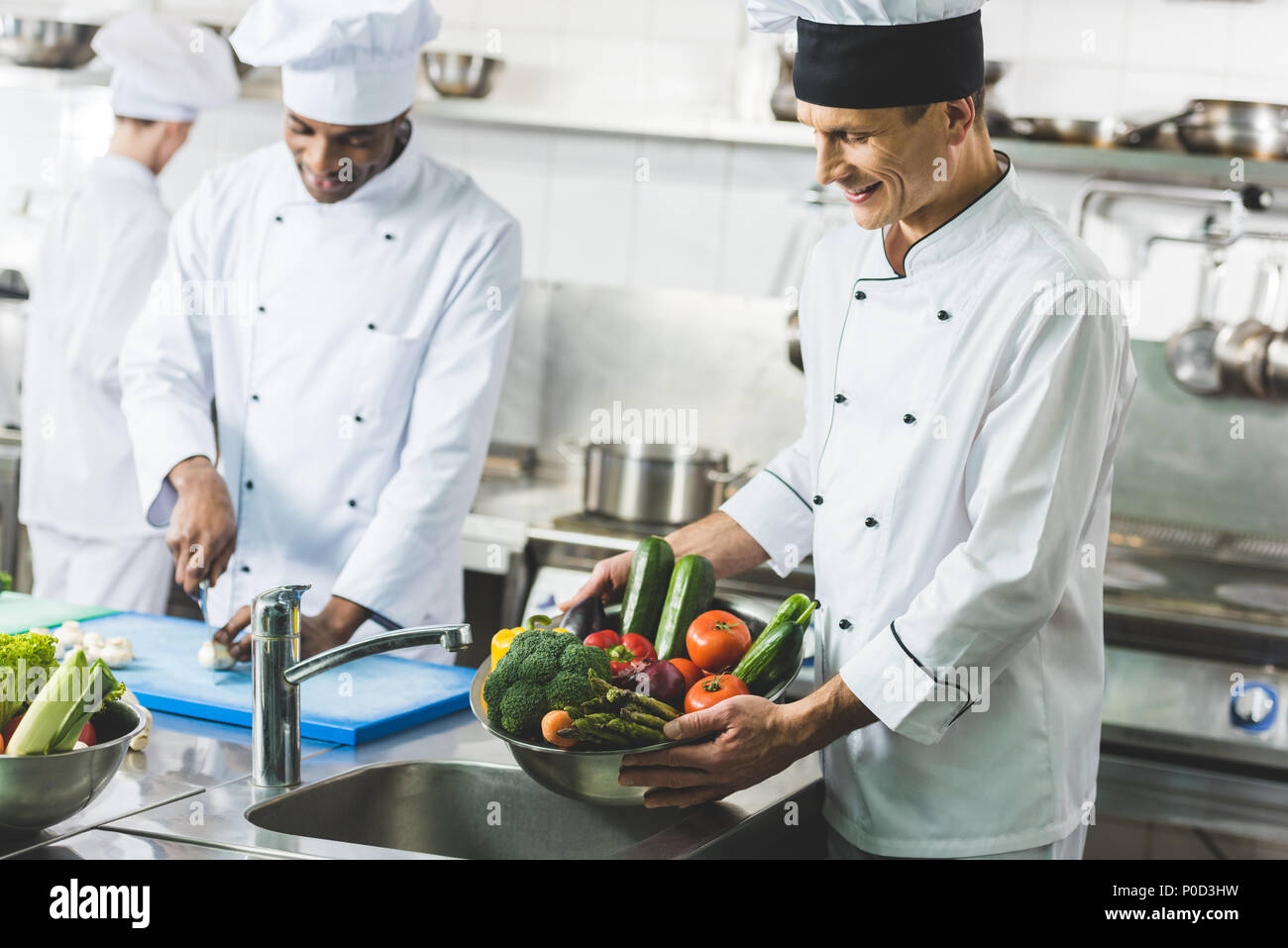 happy multicultural chefs working at restaurant kitchen Stock Photo - Alamy