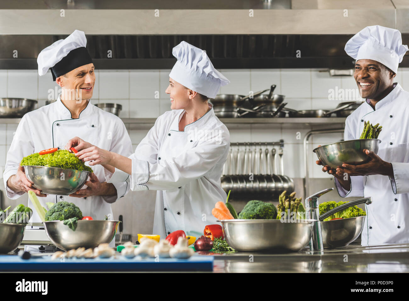 cheerful multicultural chefs cooking at restaurant kitchen Stock Photo ...