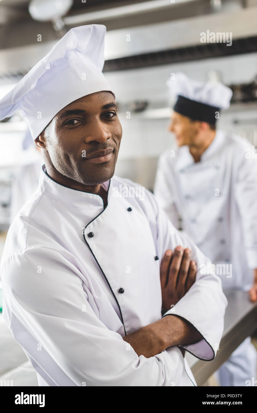 handsome african american chef looking at camera with crossed arms ...