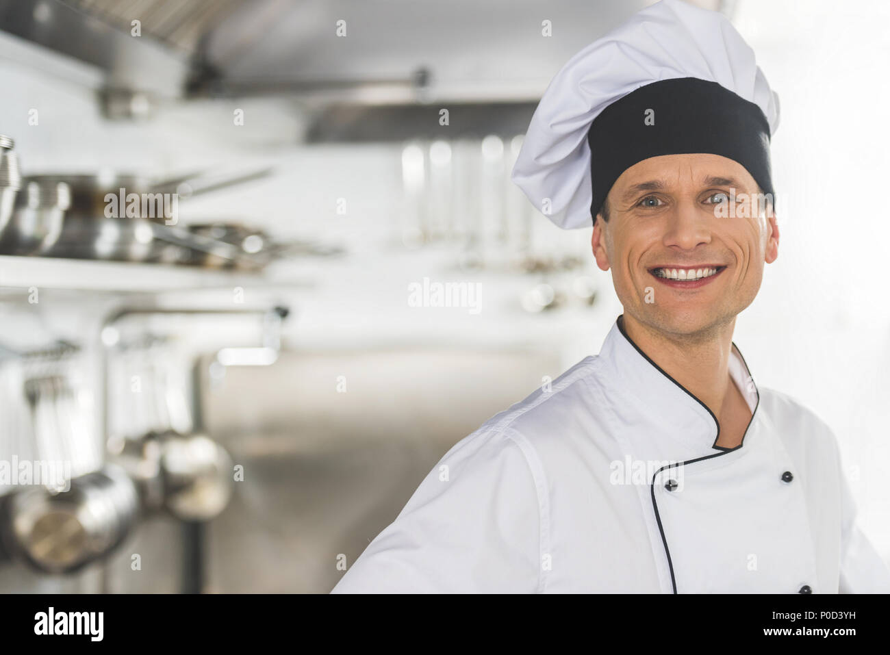 happy handsome chef looking at camera at restaurant kitchen Stock Photo ...