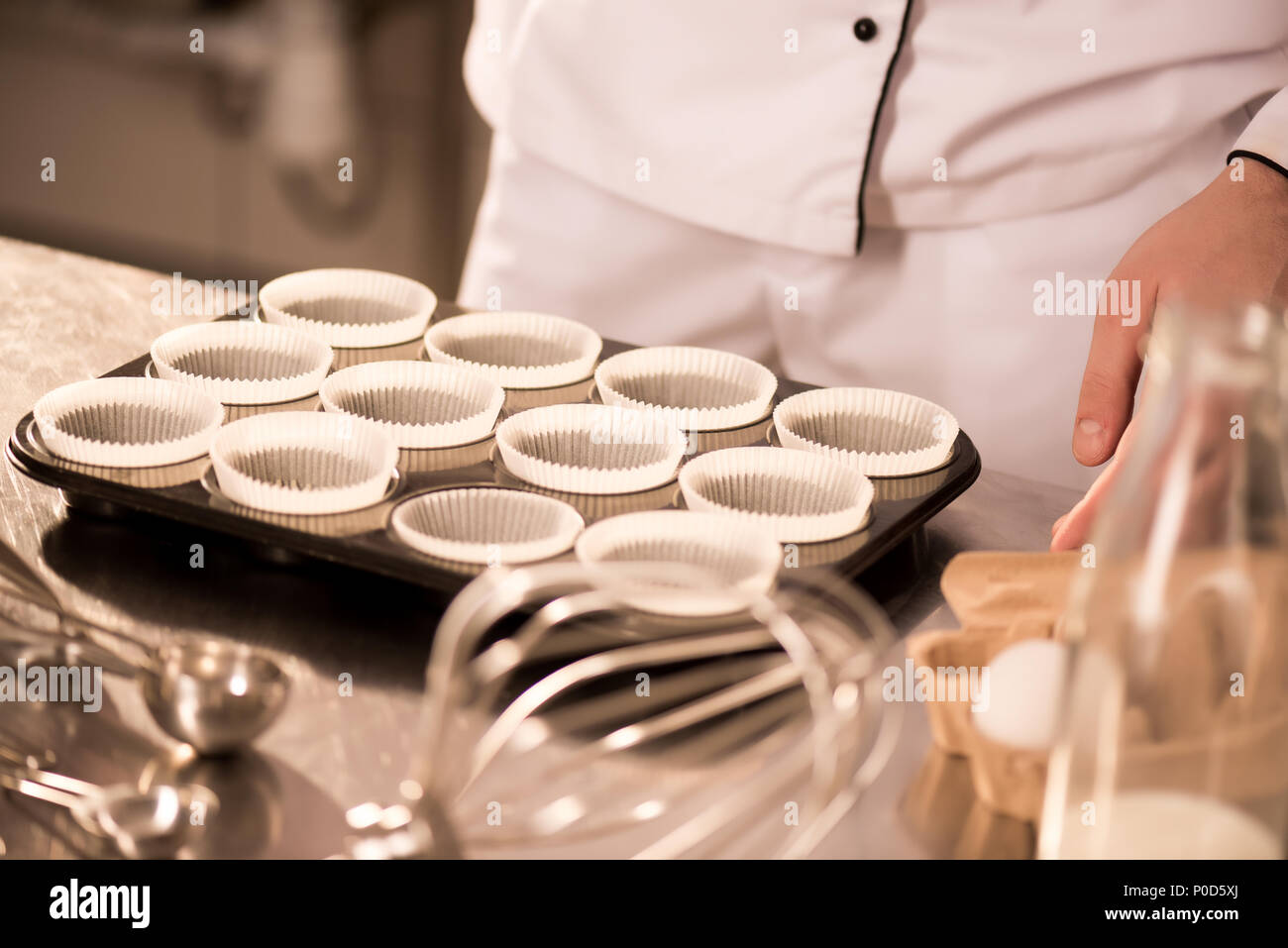 partial view of confectioner at counter with empty baking forms Stock ...