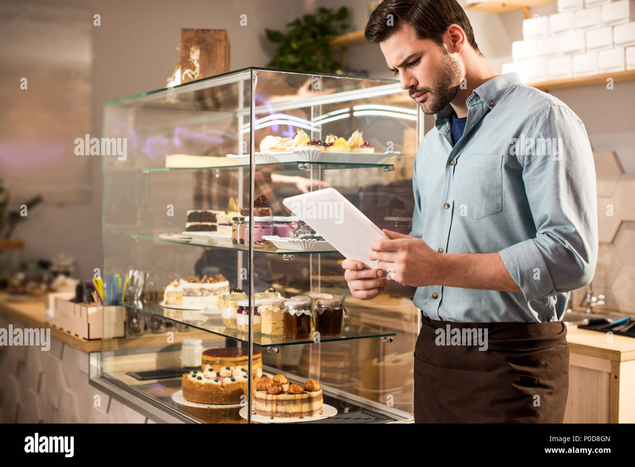 side view of barista using tablet at work in coffee shop Stock Photo ...