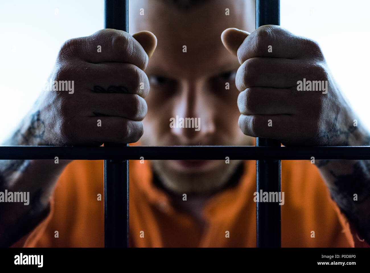 angry prisoner holding prison bars and looking at camera Stock Photo ...