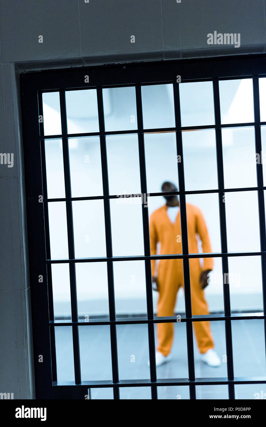 african american prisoner standing behind prison bars Stock Photo - Alamy