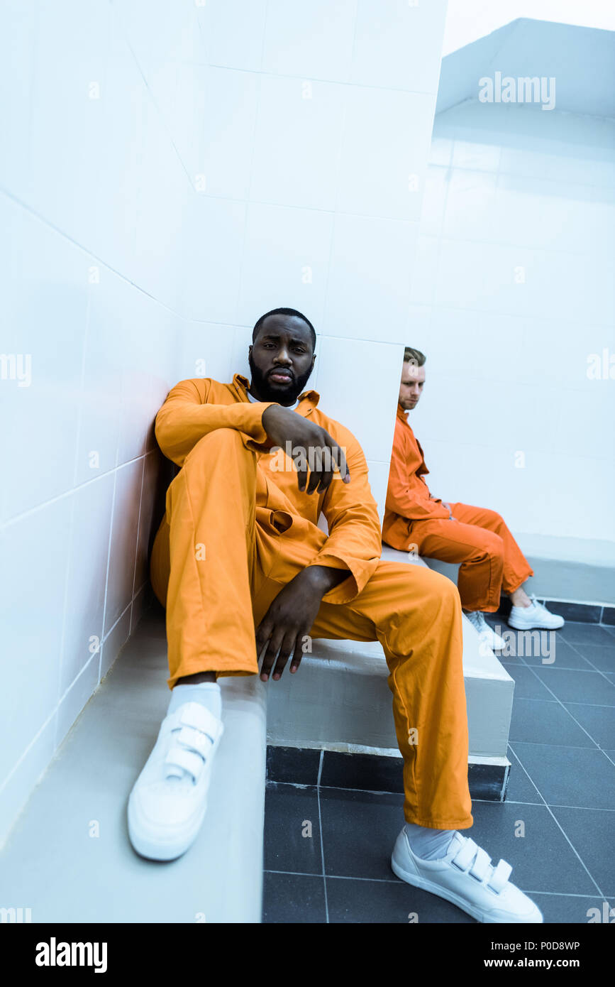 multicultural prisoners sitting on benches in prison cell Stock Photo ...