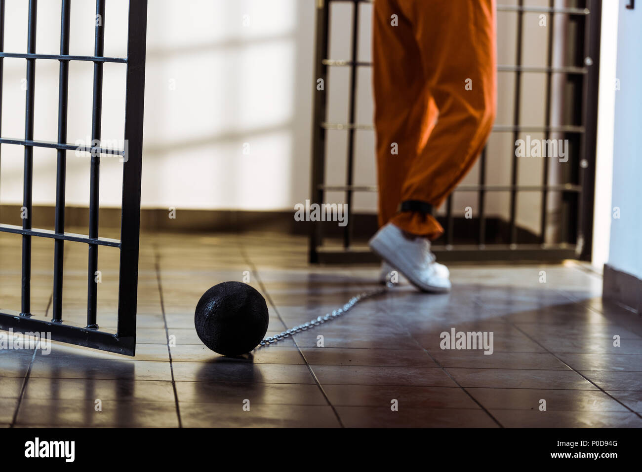 cropped image of prisoner walking in orange uniform with weight ...