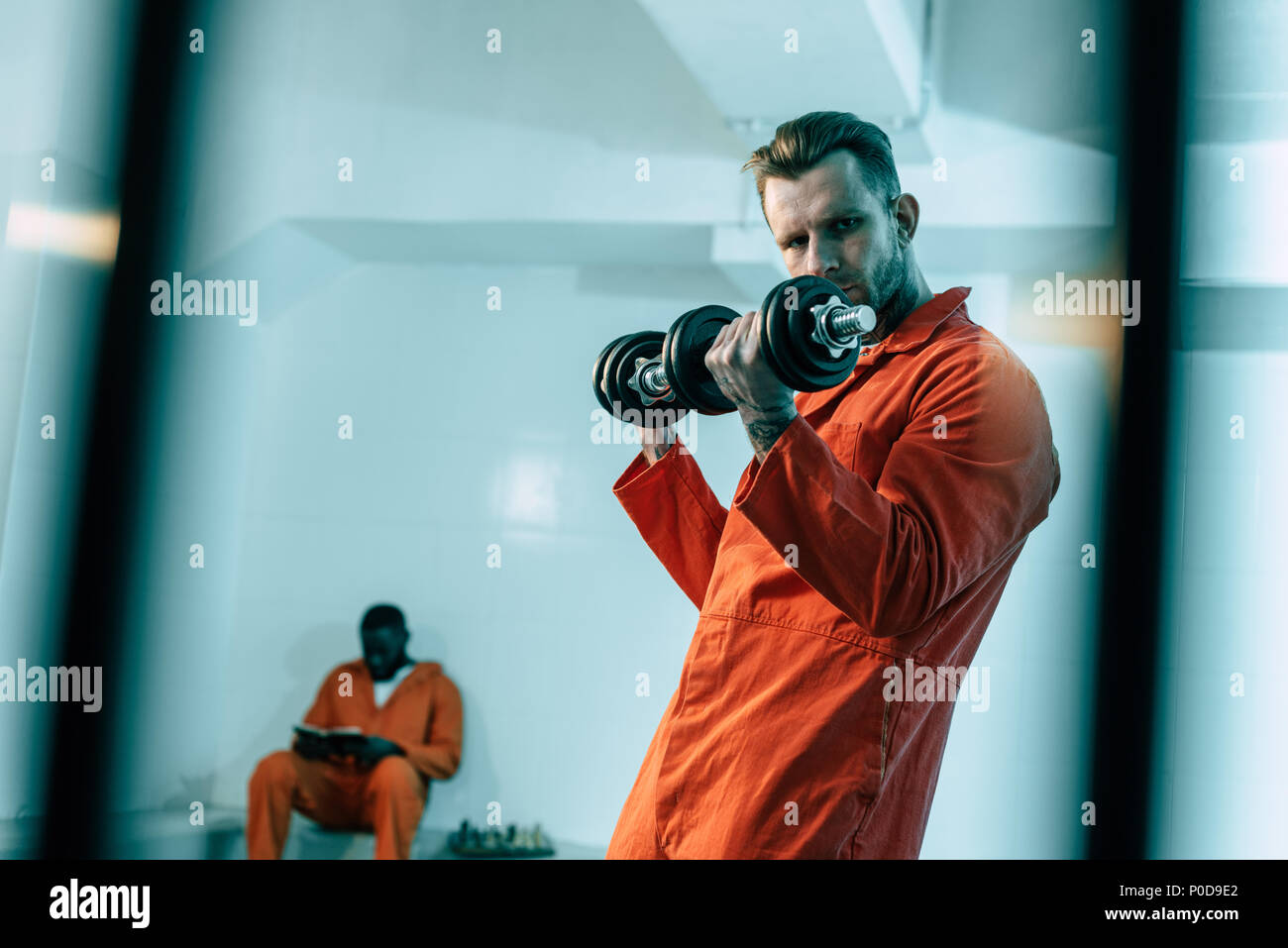 prisoner training with dumbbells in prison room Stock Photo - Alamy
