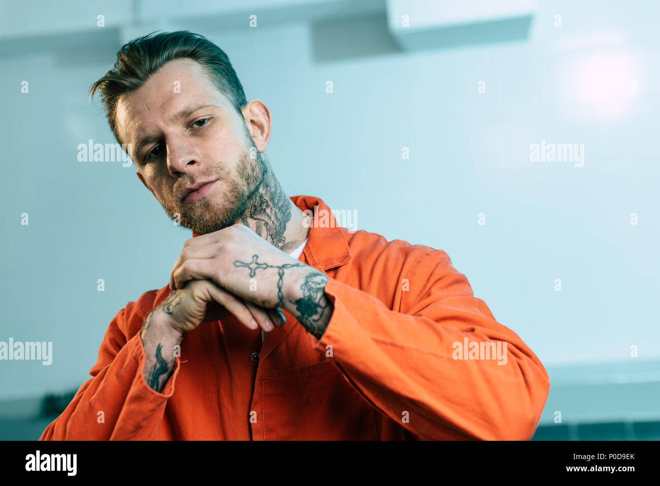prisoner with tattoos looking at camera in prison cell Stock Photo - Alamy
