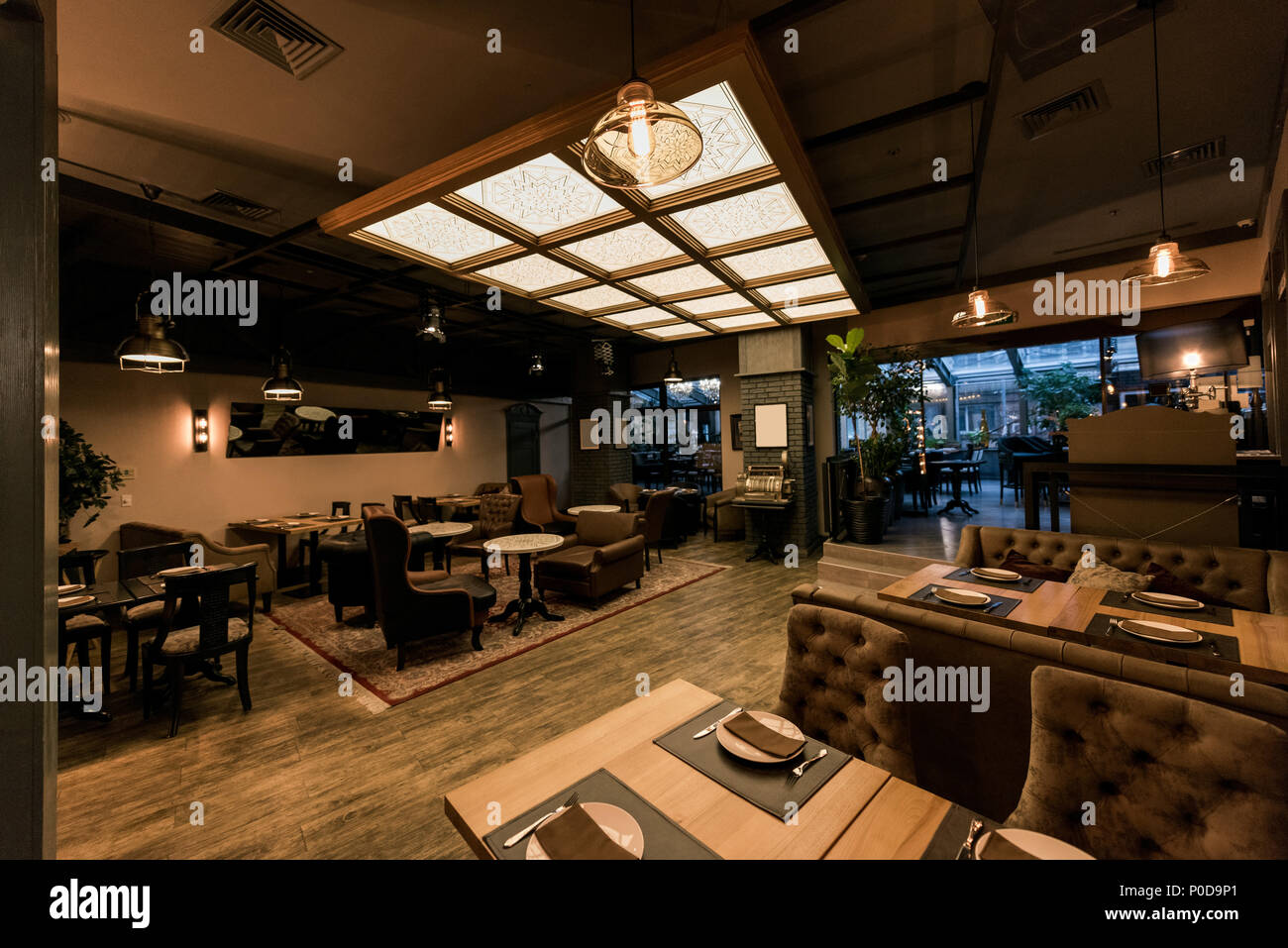 view of stylish empty cafe with arranged tables and chairs for visitors ...