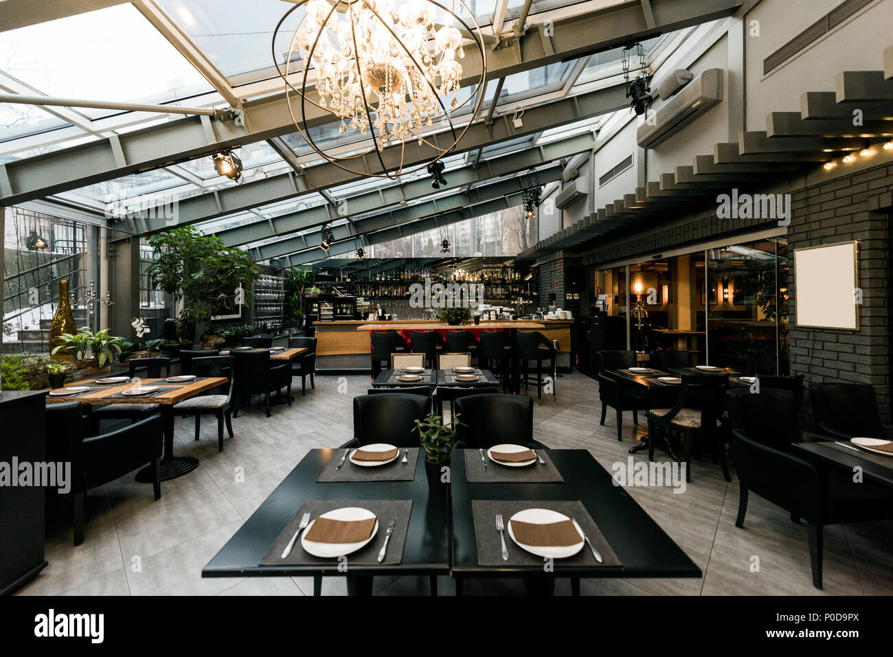 view of stylish empty cafe with arranged tables and chairs for visitors ...