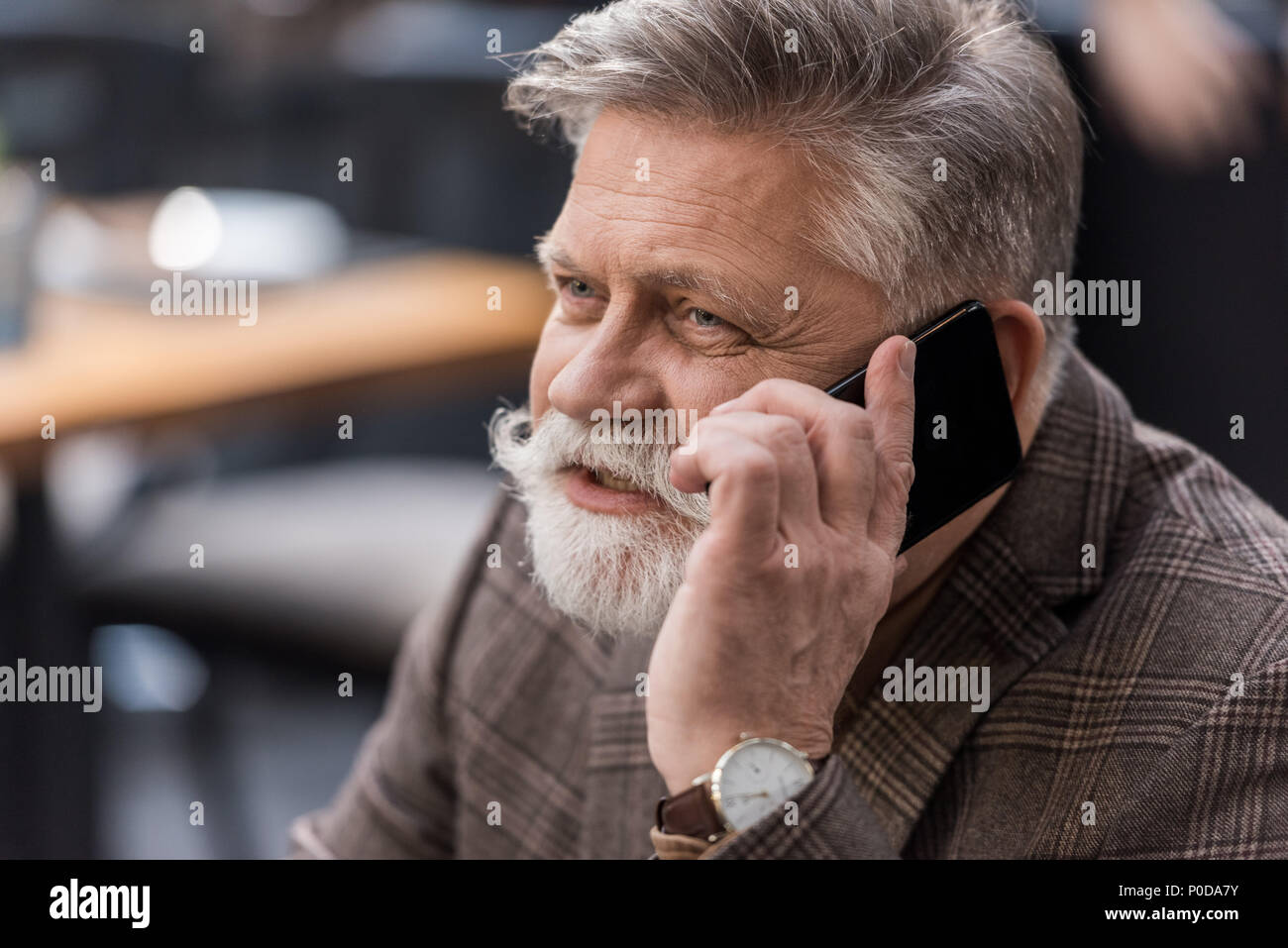 portrait of senior businessman talking on smartphone Stock Photo - Alamy