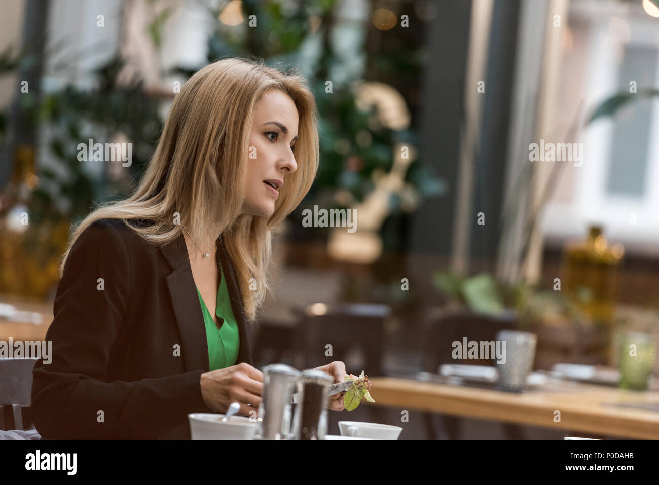 side view of woman having dinner in restaurant Stock Photo - Alamy