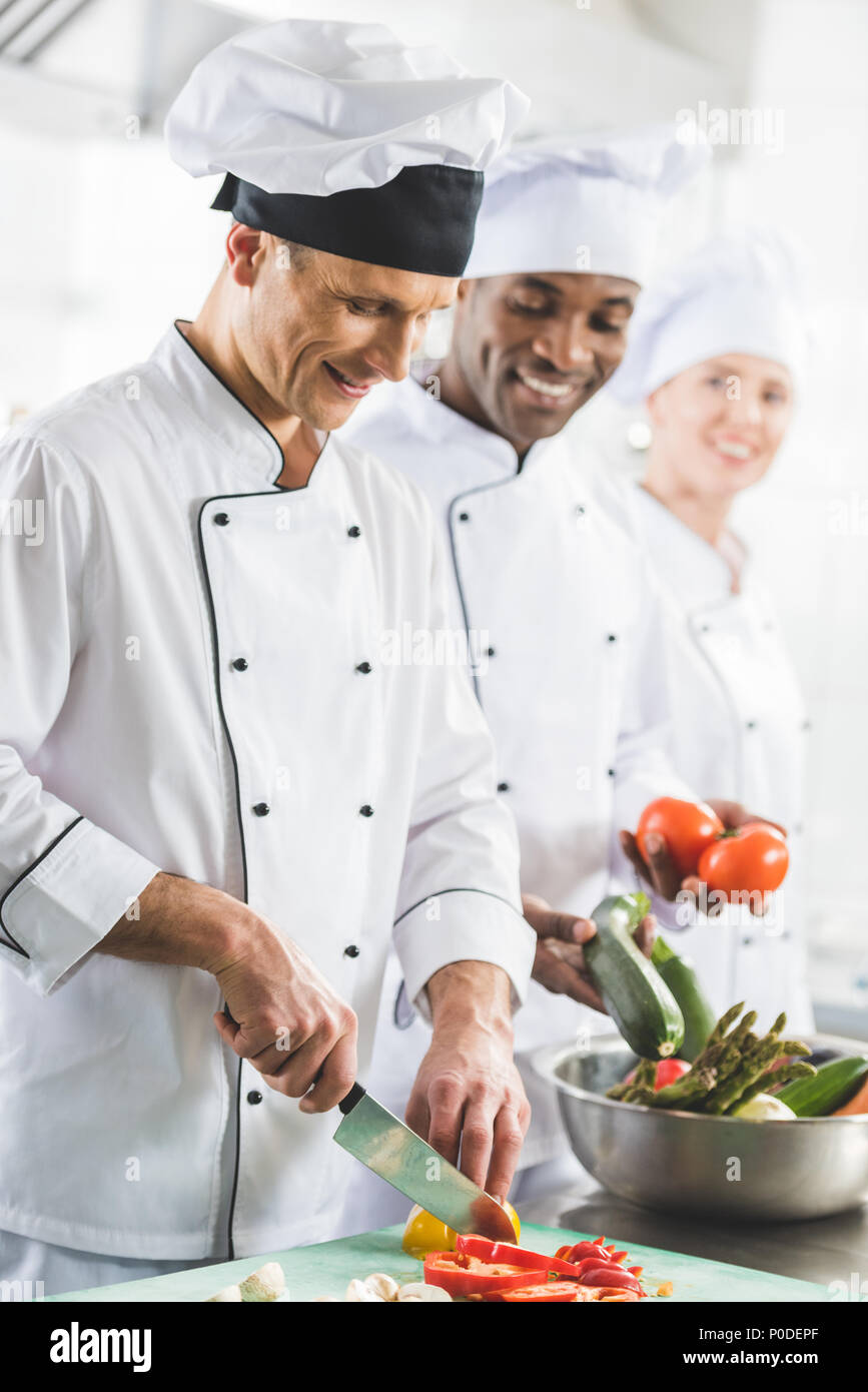 smiling multicultural chefs cooking at restaurant kitchen Stock Photo ...