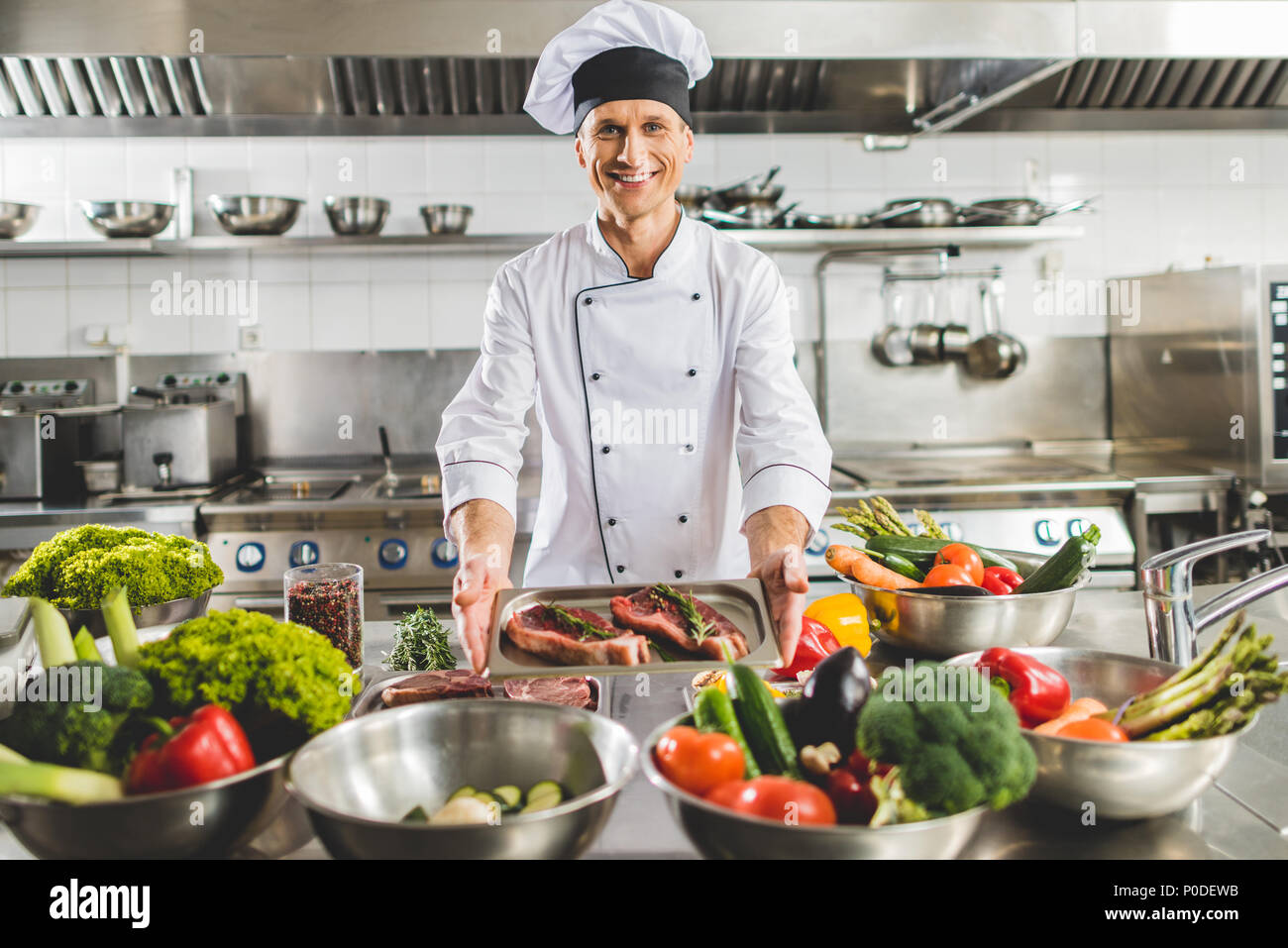 smiling chef taking tray with raw meat at restaurant kitchen Stock ...