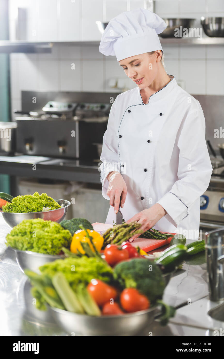 attractive chef cutting vegetables at restaurant kitchen Stock Photo ...