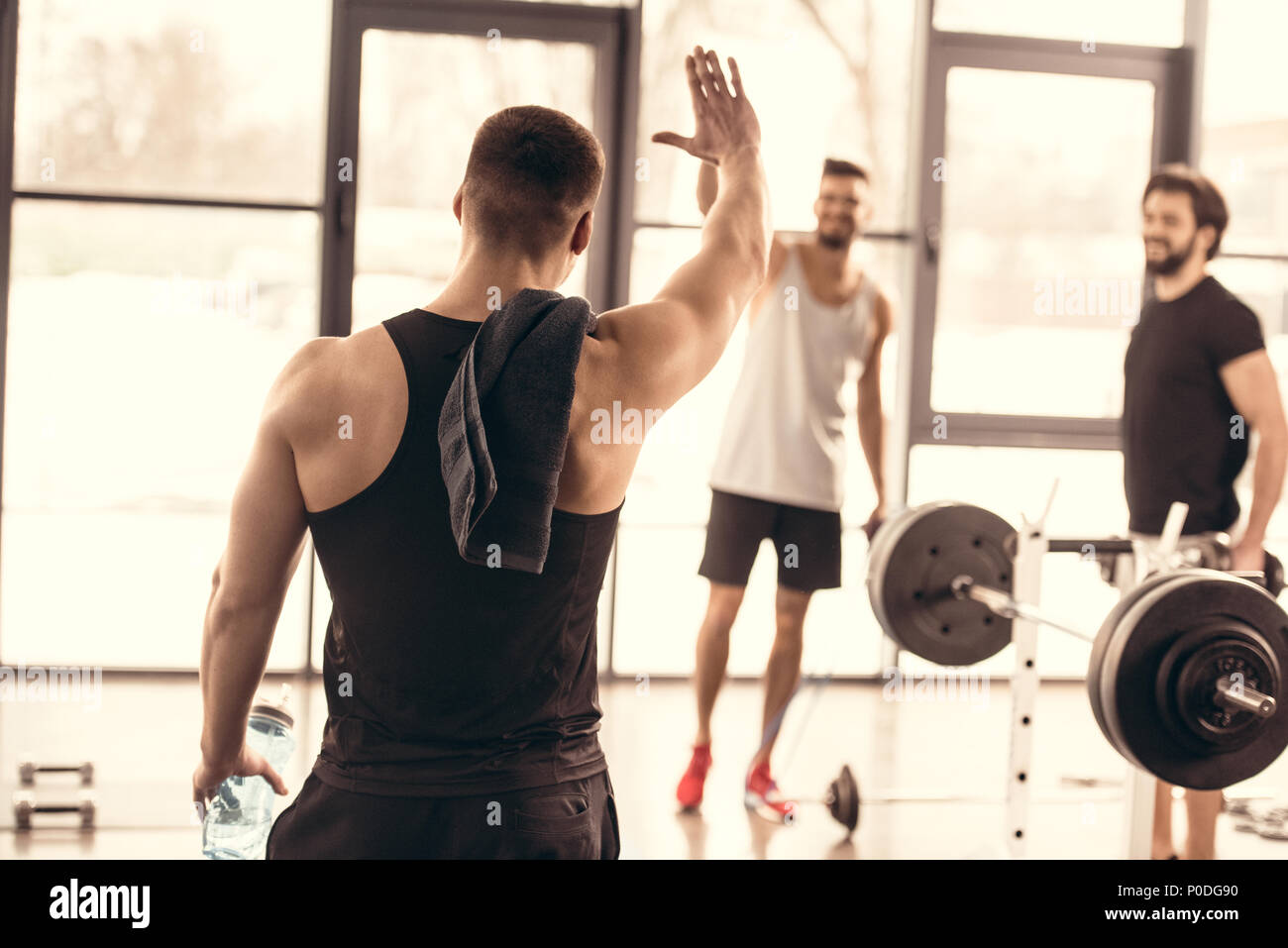 handsome sportsmen waving hands in gym Stock Photo - Alamy