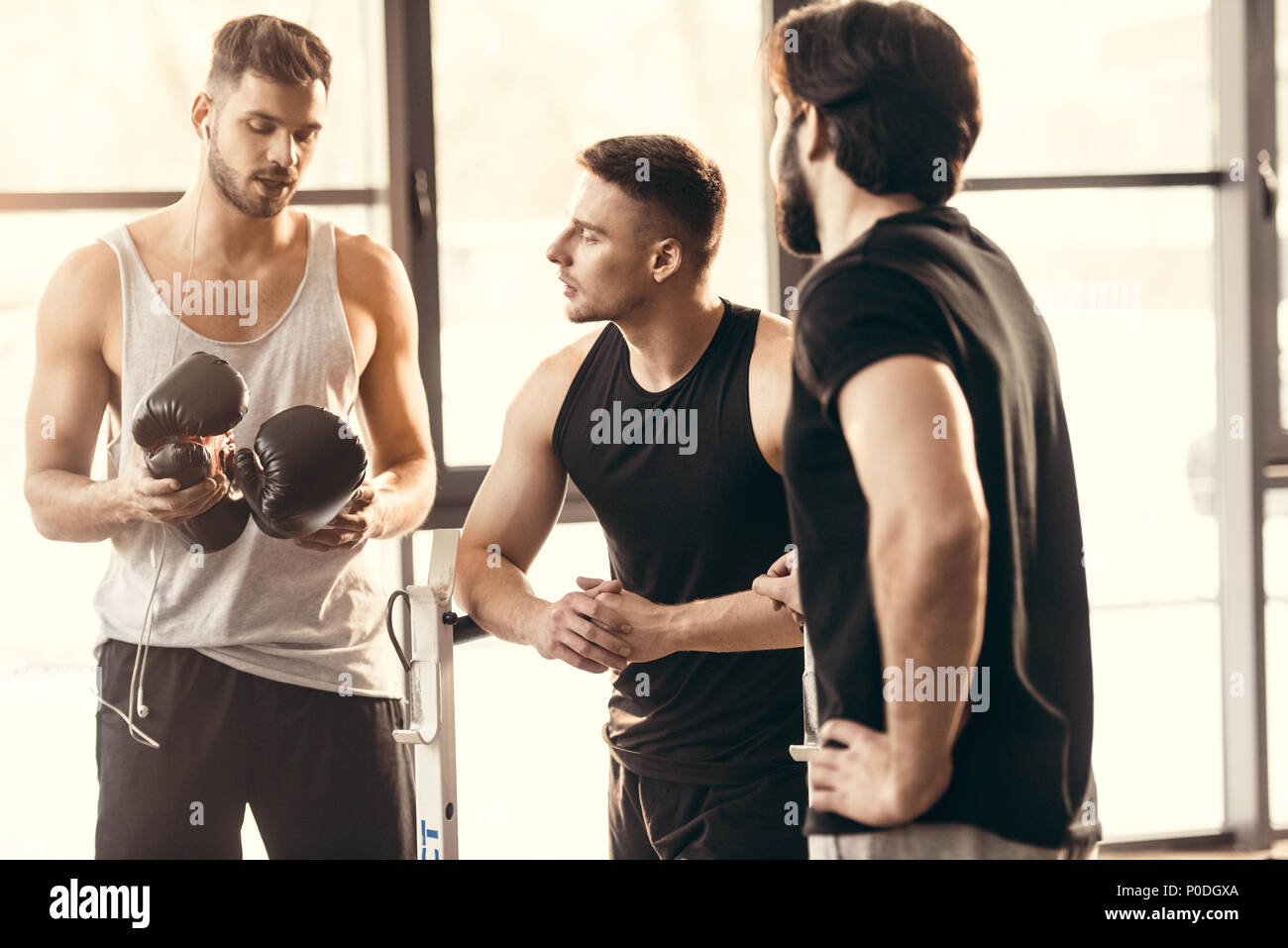three athletic young men on sportswear talking in gym Stock Photo - Alamy