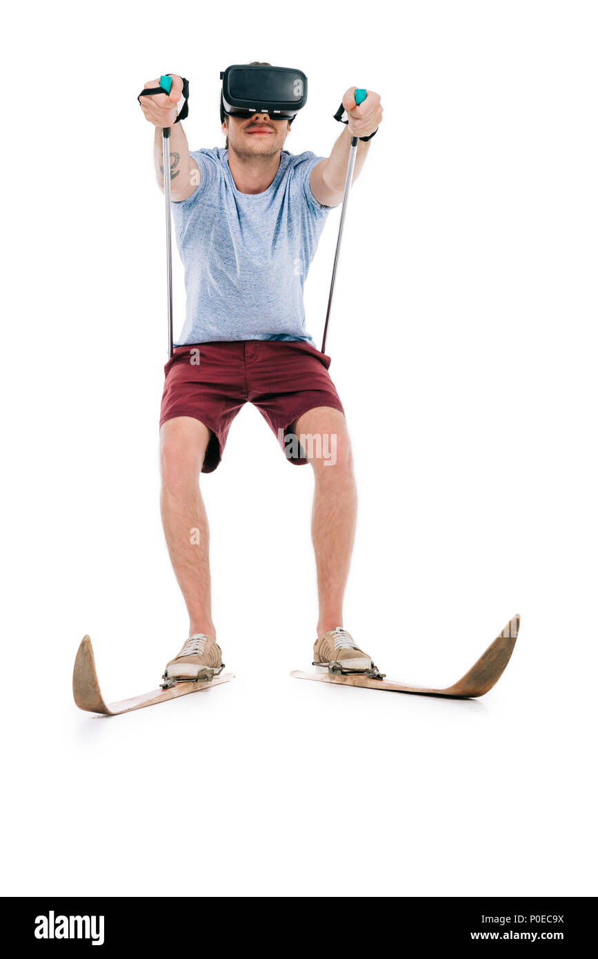young man in virtual reality headset holding ski sticks and skiing ...