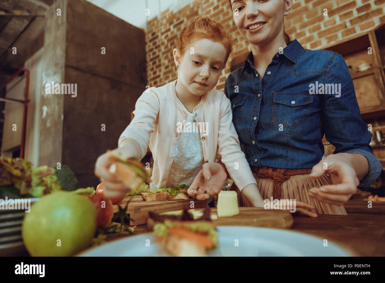 little girl helping mother cooking dinner for family at home Stock ...