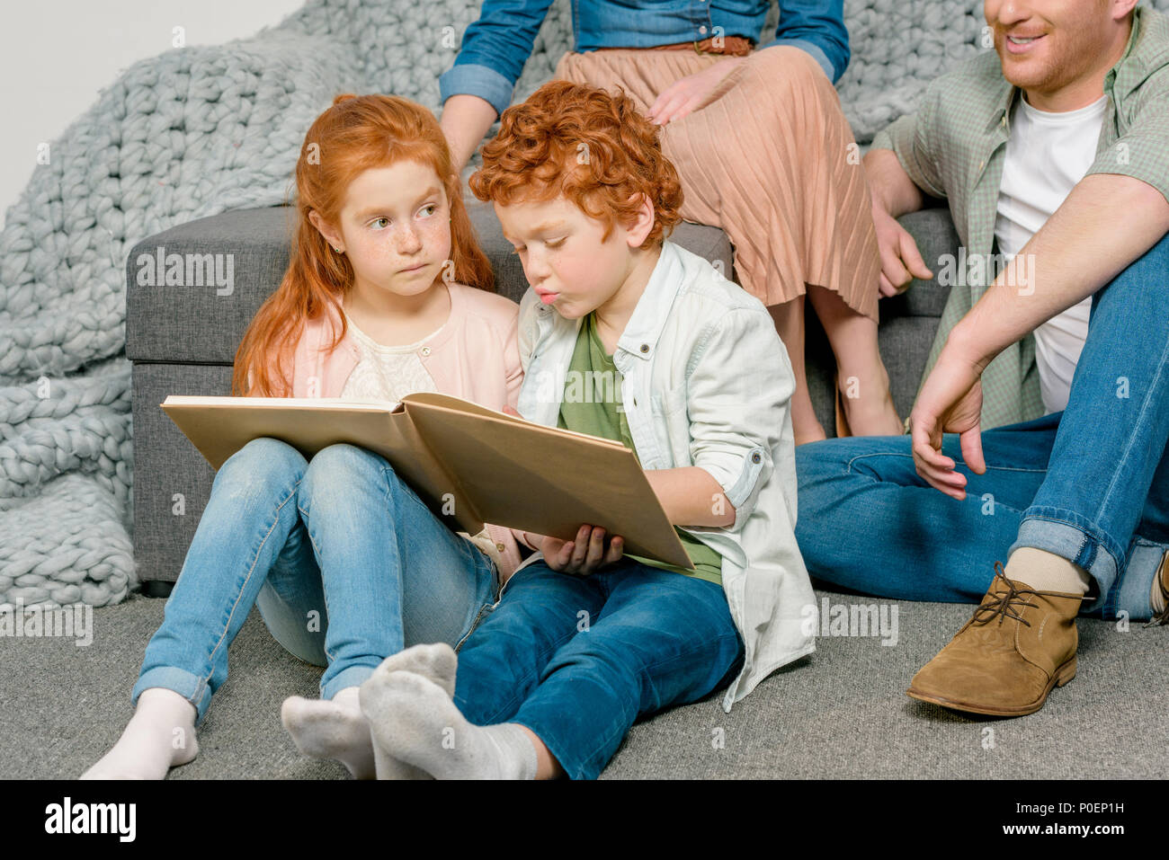 little cute siblings reading book together at home Stock Photo - Alamy