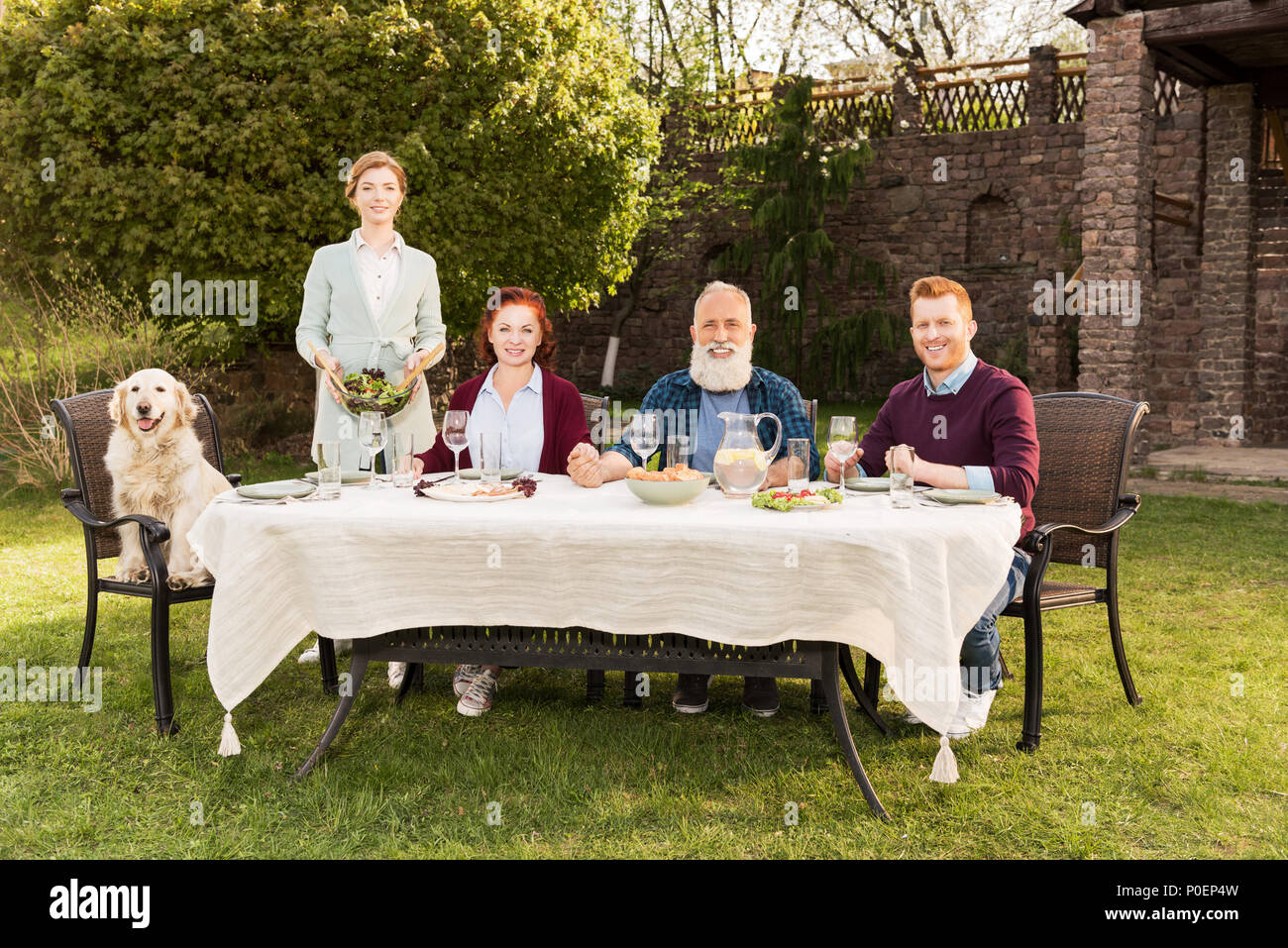 smiling family sitting at table while having dinner together at ...