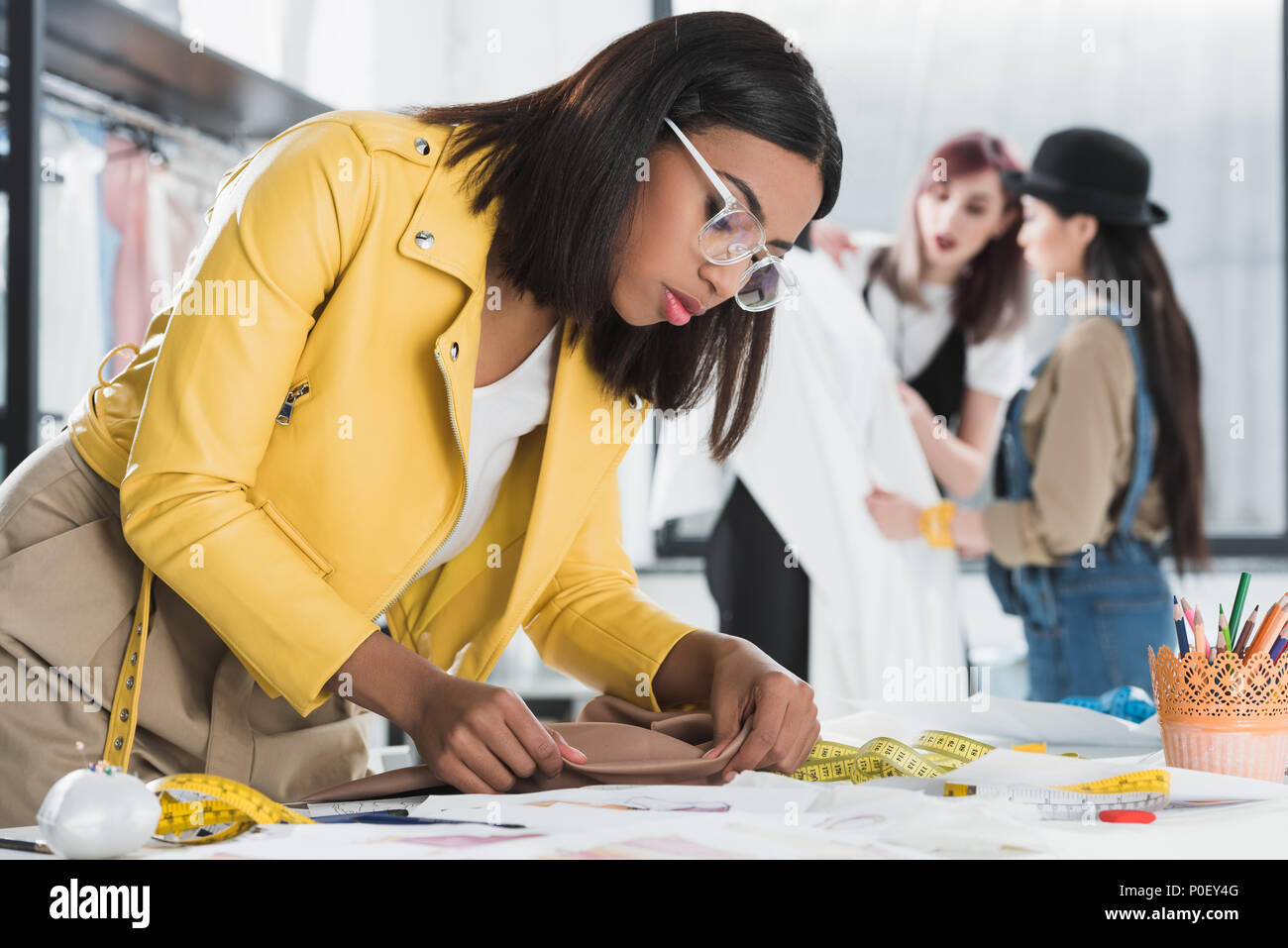 side view of confident fashion designer working with textile at ...