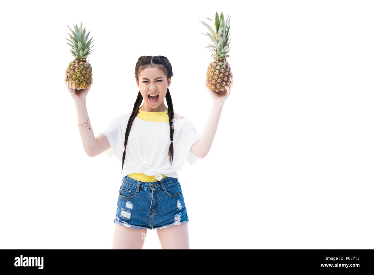 excited asian girl holding rie pineapples and screaming isolated on ...