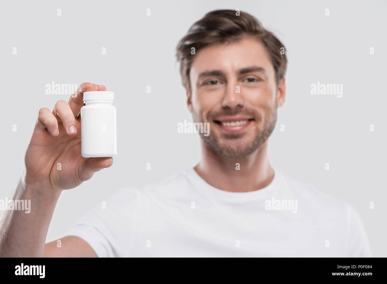 handsome man presenting vitamins in bottle, isolated on white Stock ...