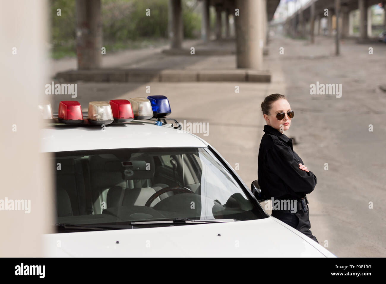 female police officer with crossed arms leaning on patrol car Stock ...