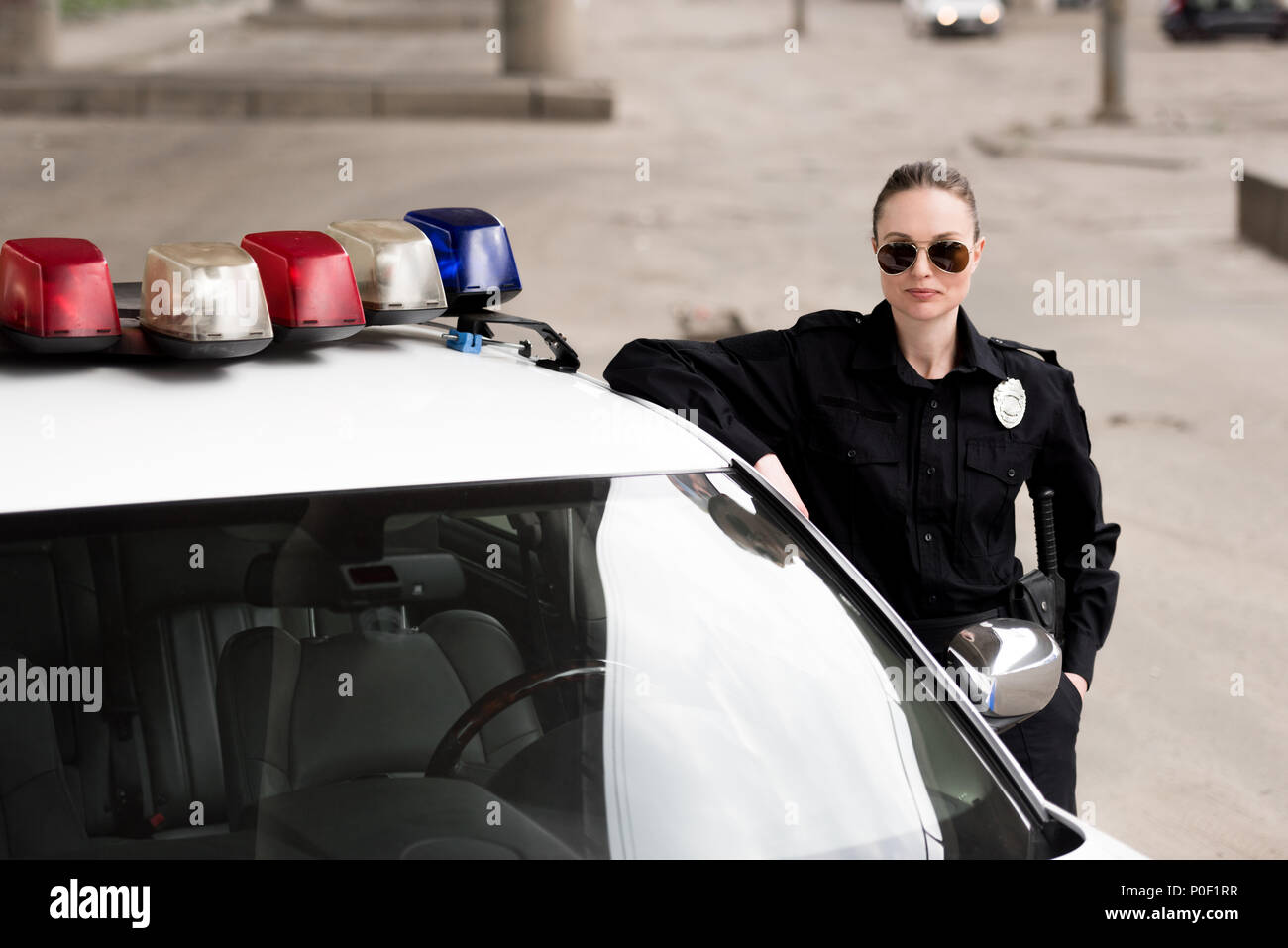 female police officer leaning on patrol car Stock Photo - Alamy
