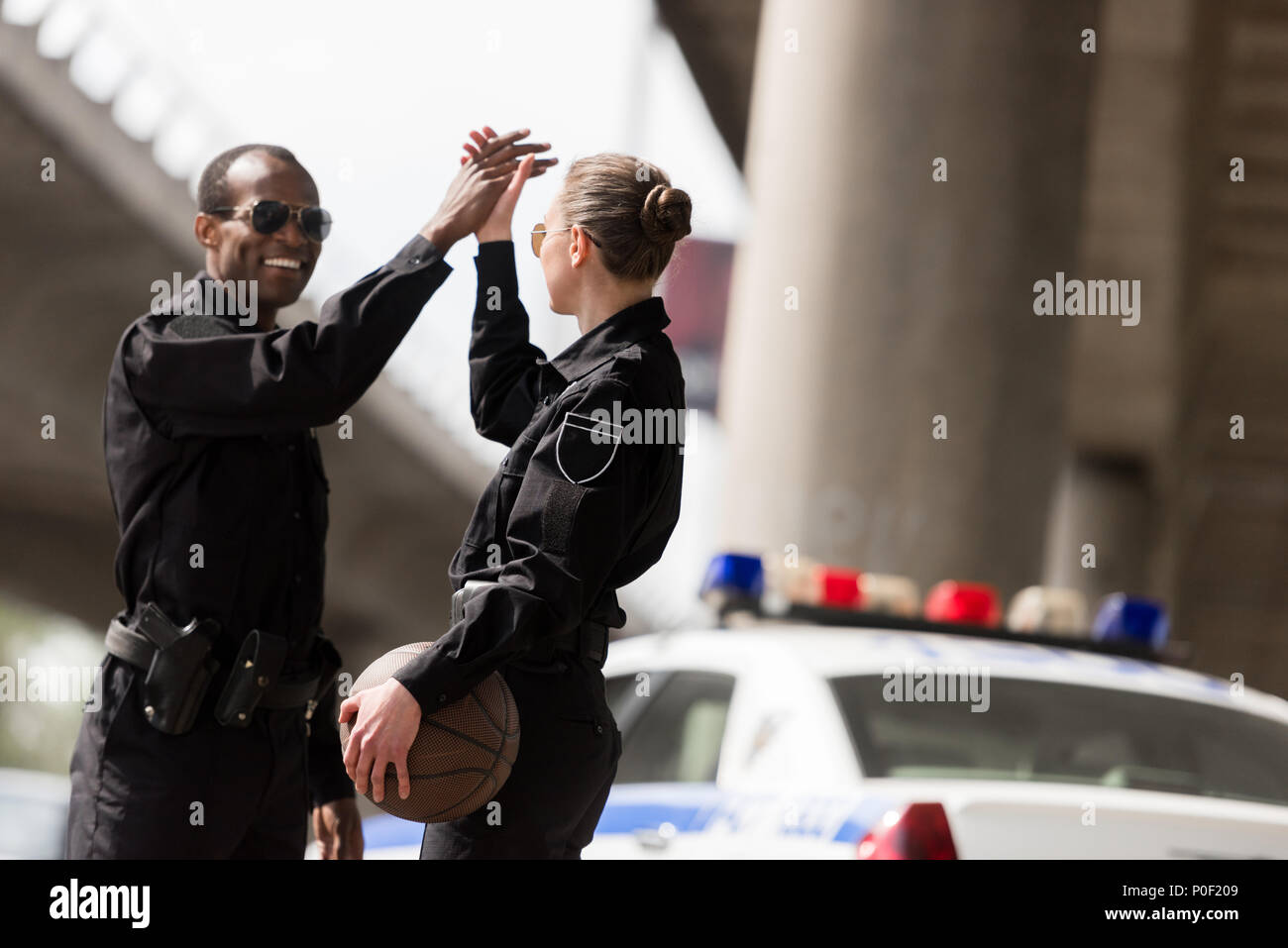 happy police officers with basketball ball giving high five Stock Photo ...