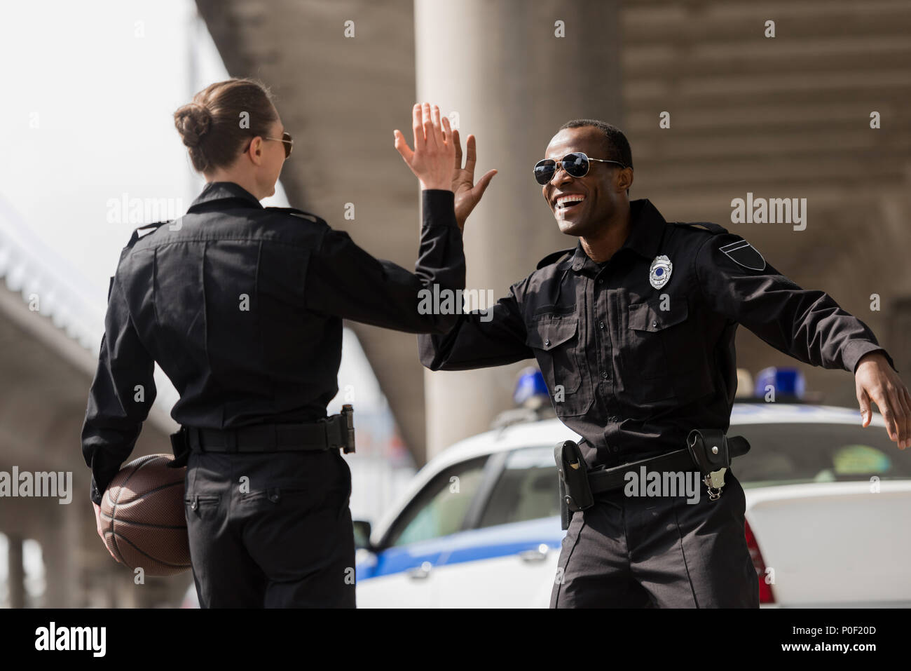 police officers with basketball ball giving high five Stock Photo - Alamy