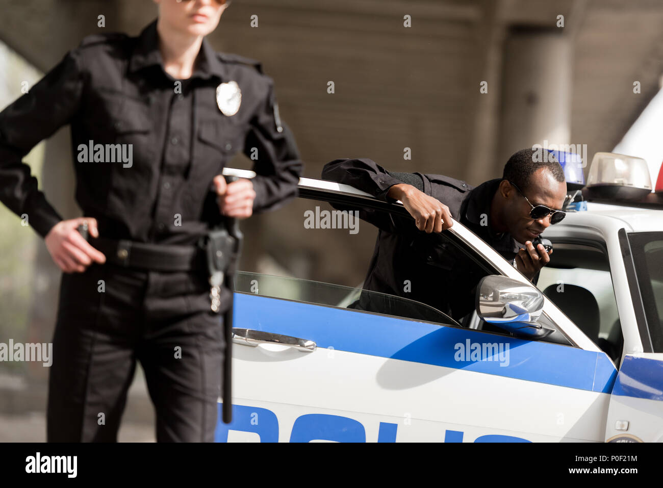 young police officers standing near car Stock Photo - Alamy