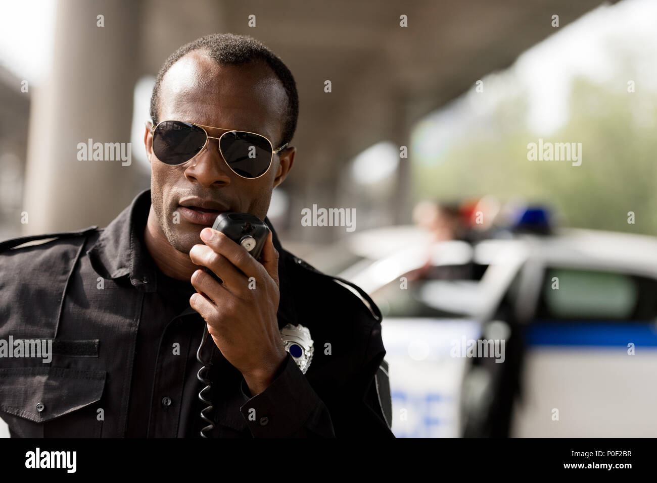 african american police officer talking by walkie-talkie radio set ...