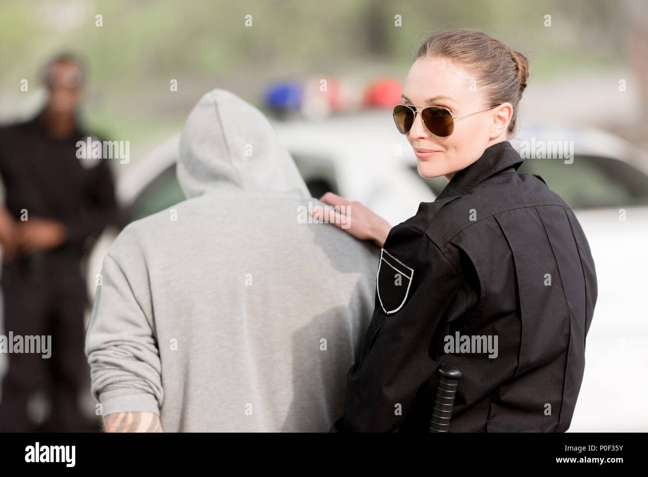 smiling policewoman in sunglasses with arrested criminal Stock Photo ...