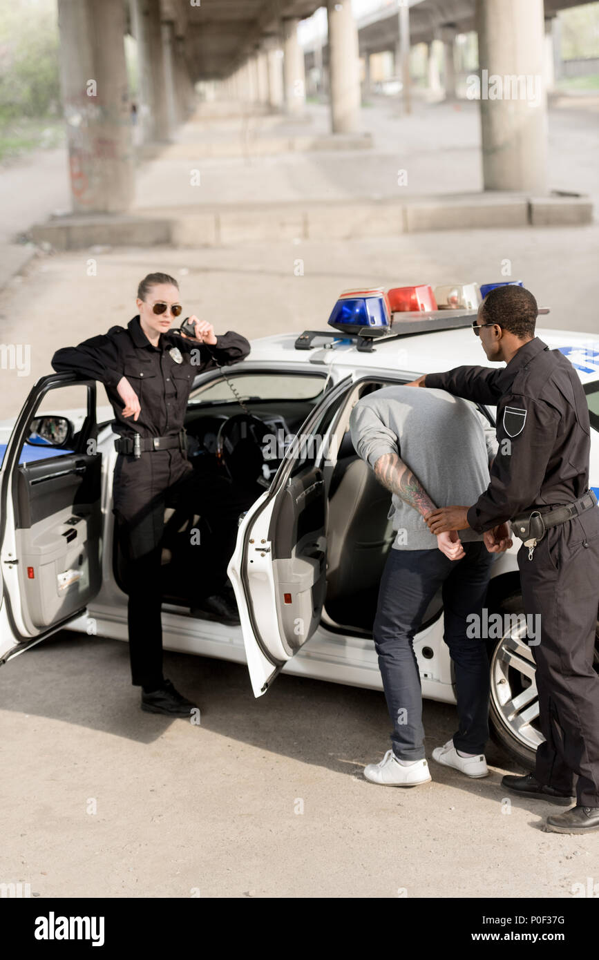 policewoman talking on portable radio while her partner holding ...