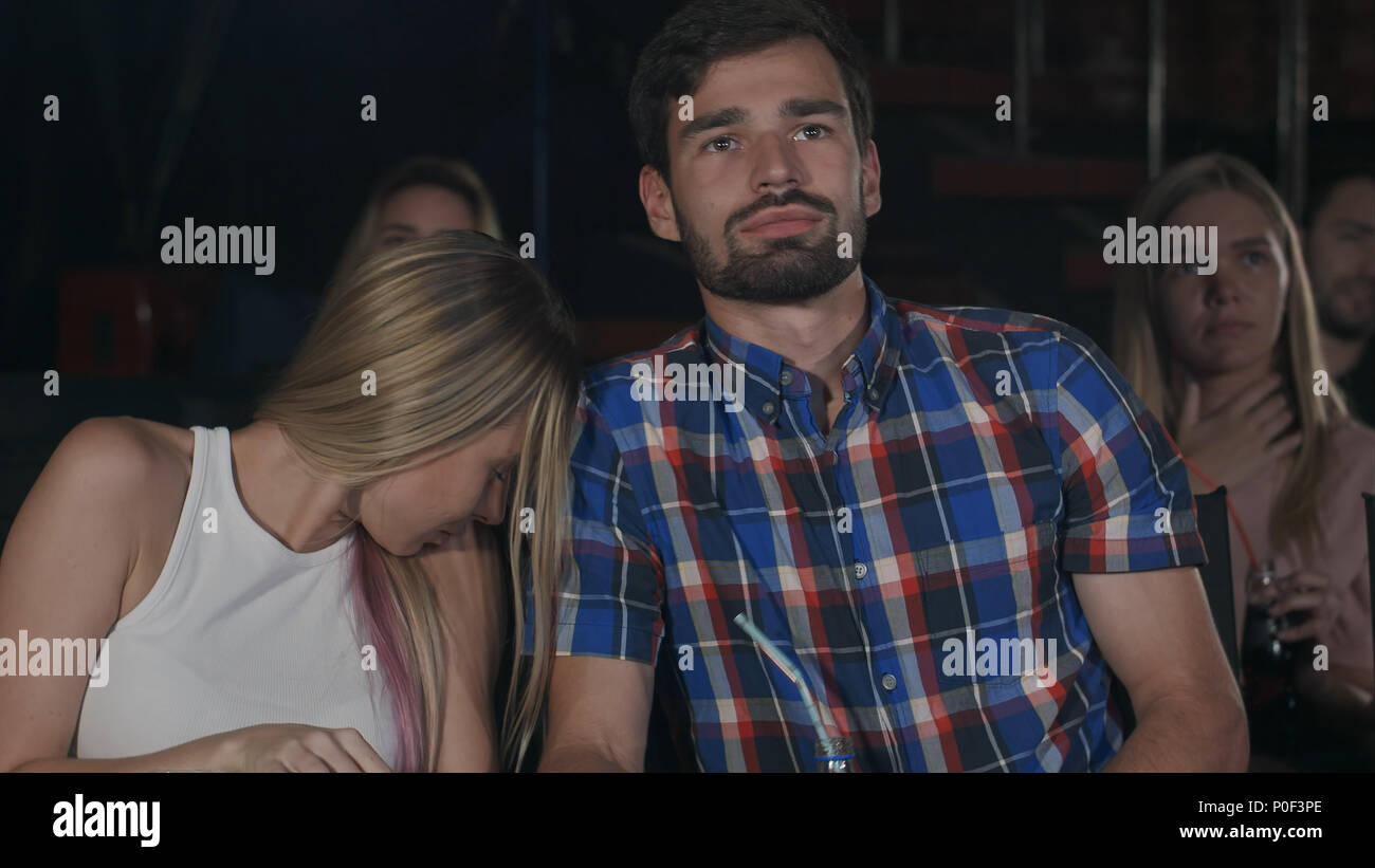 Young couple watching horror movie in cinema, girl turning her head ...